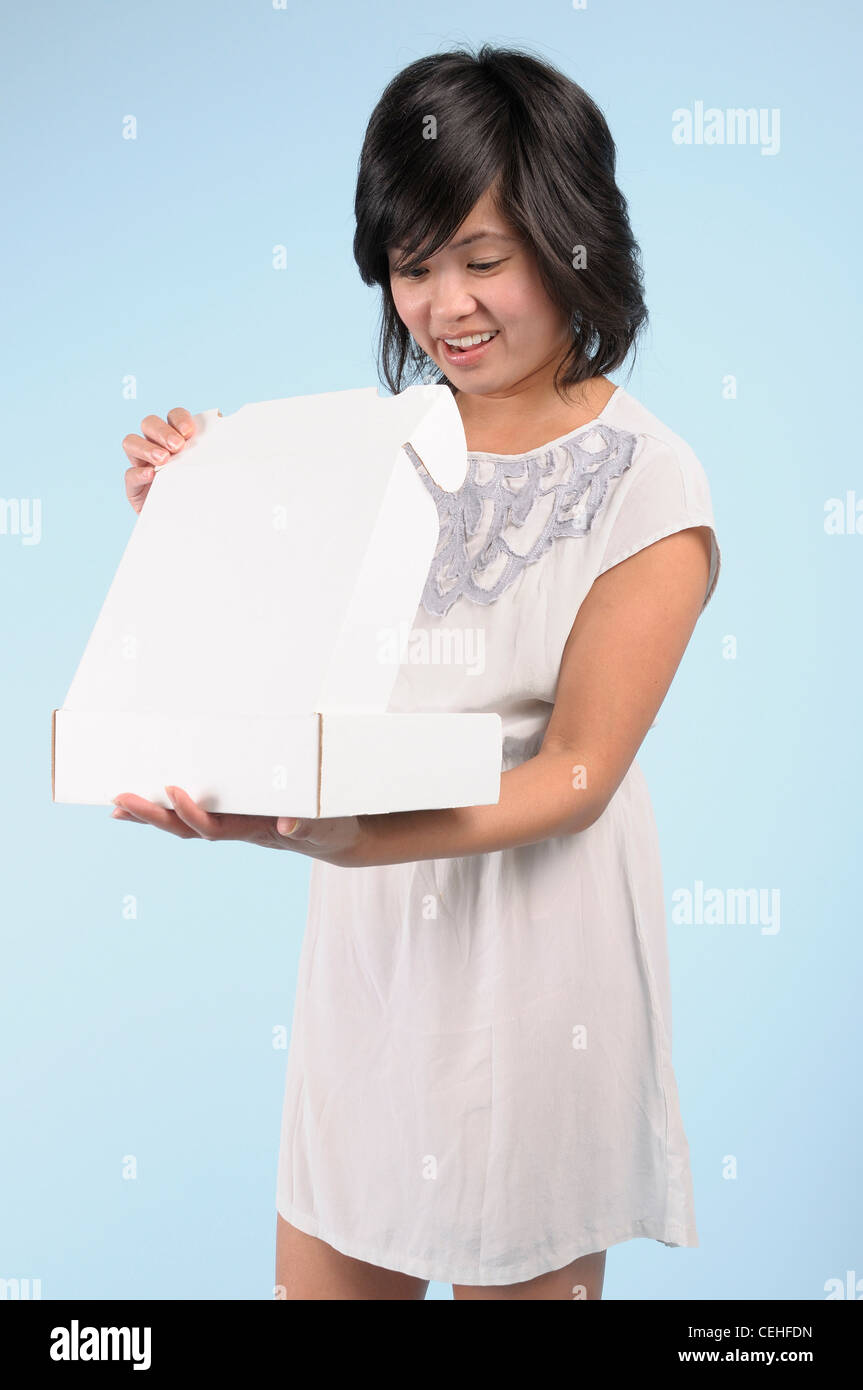 Young Asian woman opening a small box she is holding on her arm Stock ...