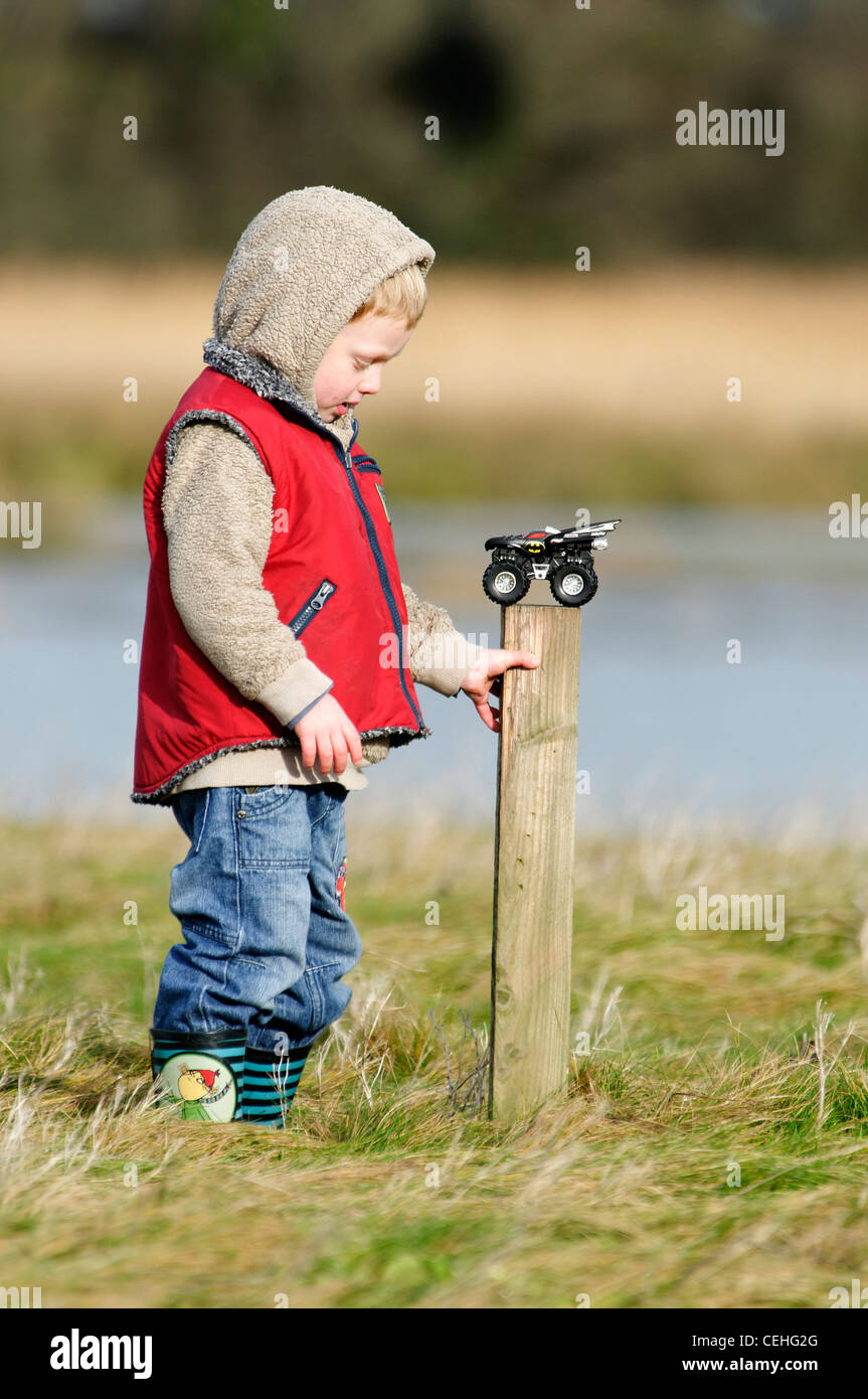 A young boy balancing a toy car on a post Stock Photo - Alamy