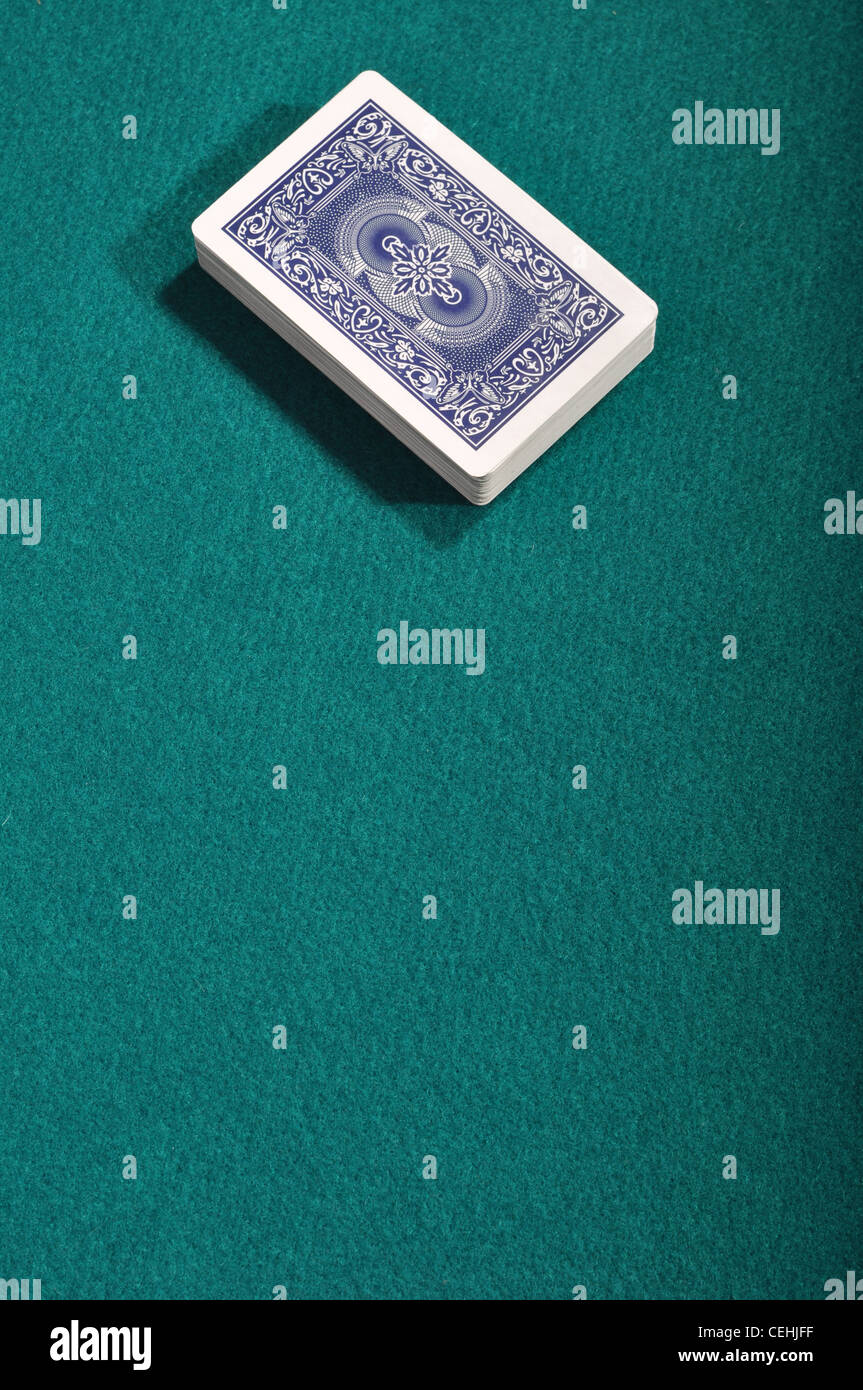 playing cards deck on a green cloth background Stock Photo - Alamy