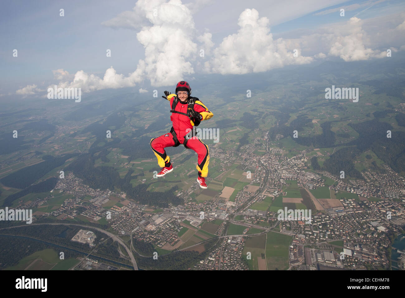 Skydiver girl is flying in sit position in free fall. She is flying ...