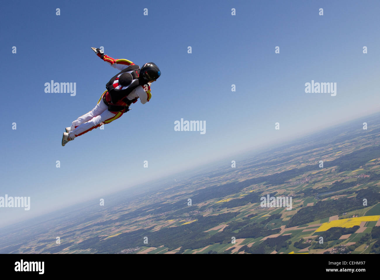 Freestyle girl is flying high in the blue sky and tracking in free fall ...