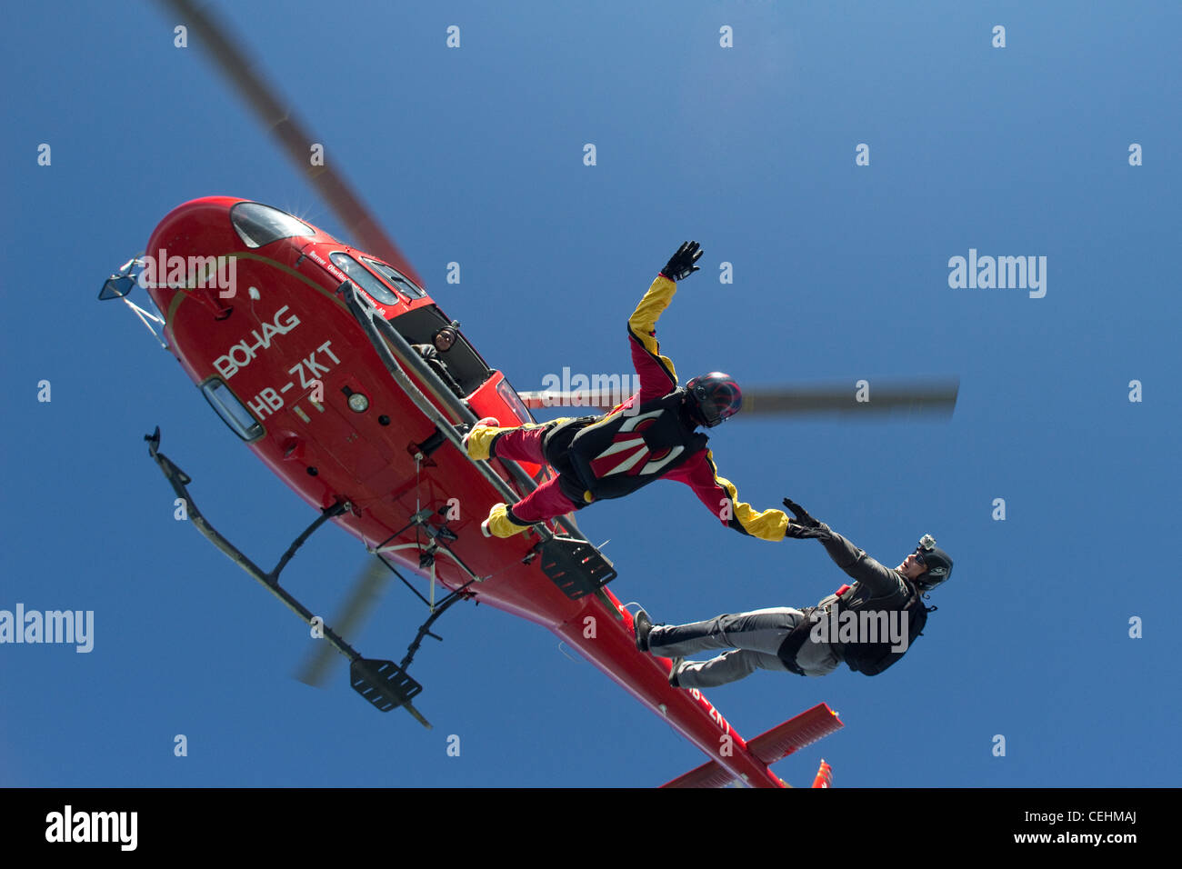 Skydivers are jumping out of a helicopter into freefall. The couple are ...