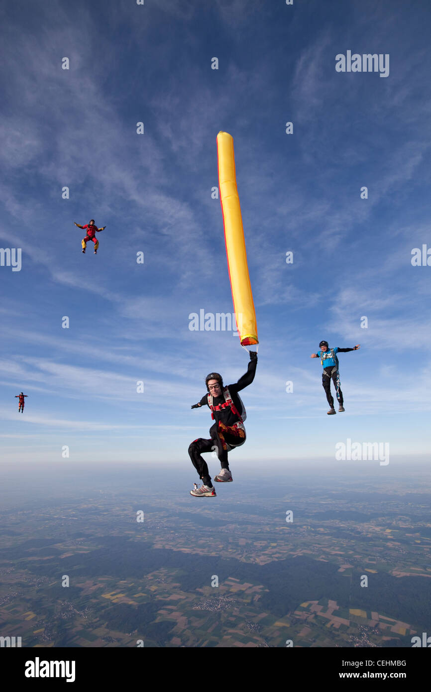 Skydiver with colorful air tube and friend are falling through the blue ...