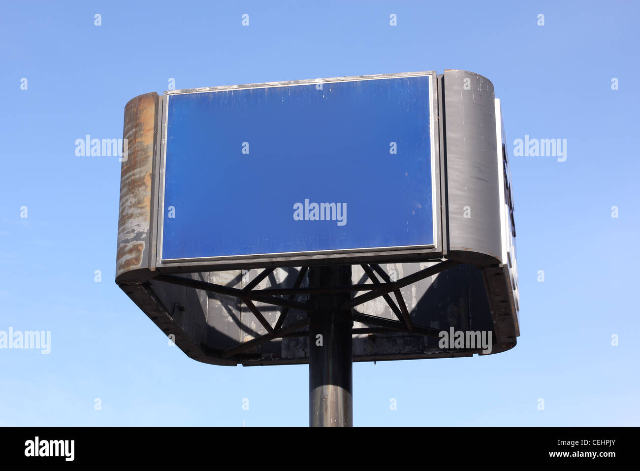 An sunlit, empty blue sign before a clear blue sky provides plenty of ...
