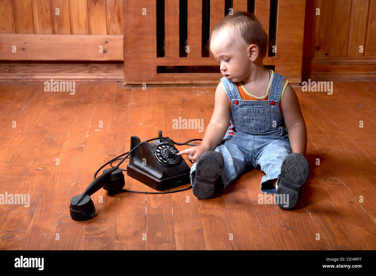 The little boy plays old phone sitting on a floor Stock Photo - Alamy