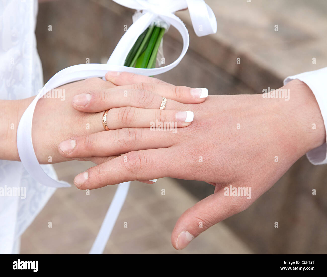 The weaved hands with rings of bridegroom and bride Stock Photo - Alamy