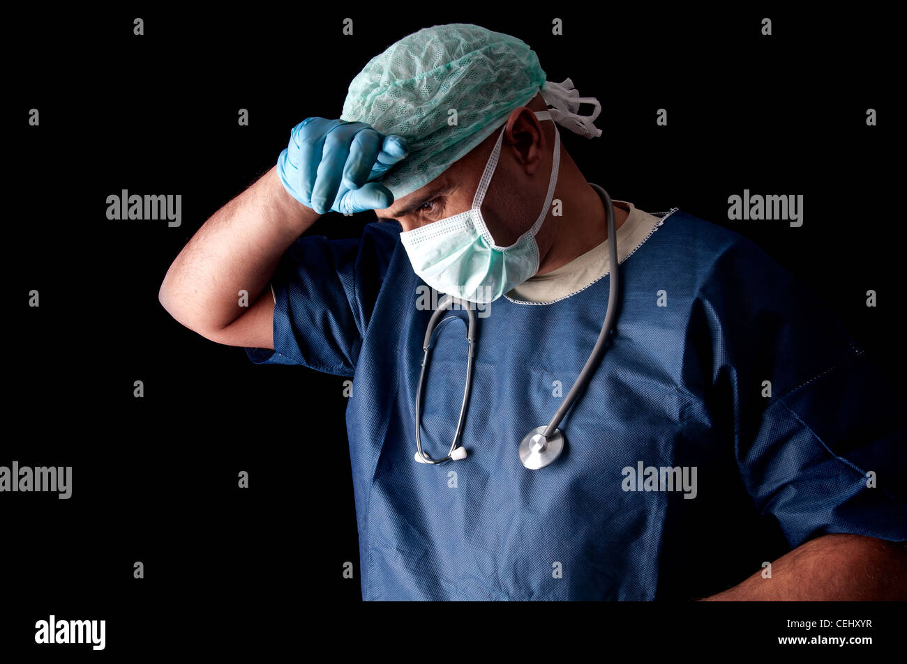 Tired doctor with mask in a dark background Stock Photo - Alamy