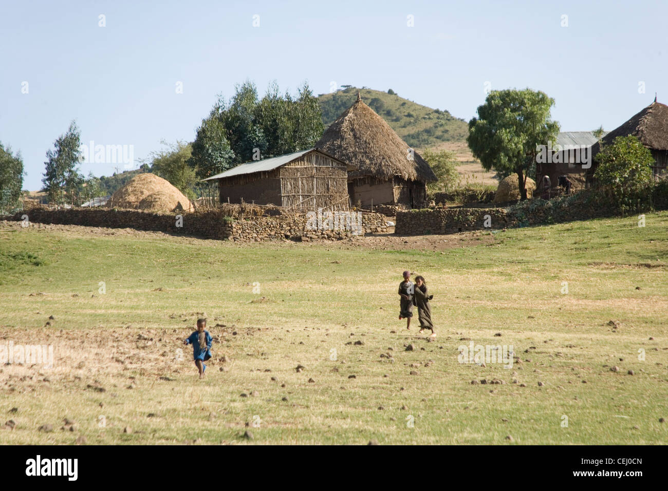 Farms and village with running children in the countryside between ...