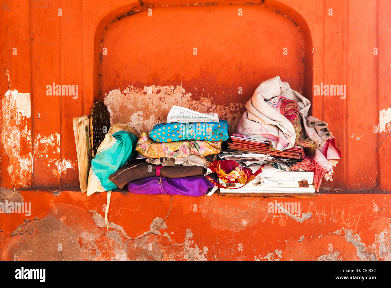 Colourful scarves and cloths wrapping copies of the Koran in terracotta ...