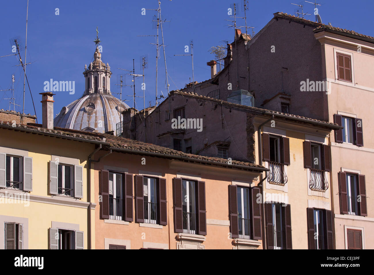 Old shuttered tenements with a lead roofed dome behind, covered in ...