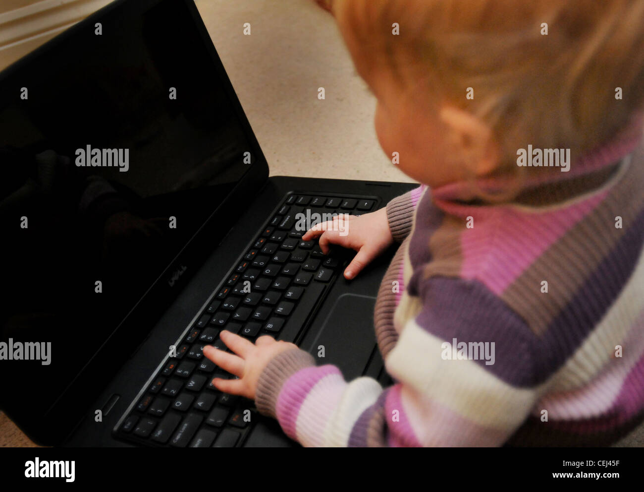 a baby looks over a laptop computer Stock Photo - Alamy