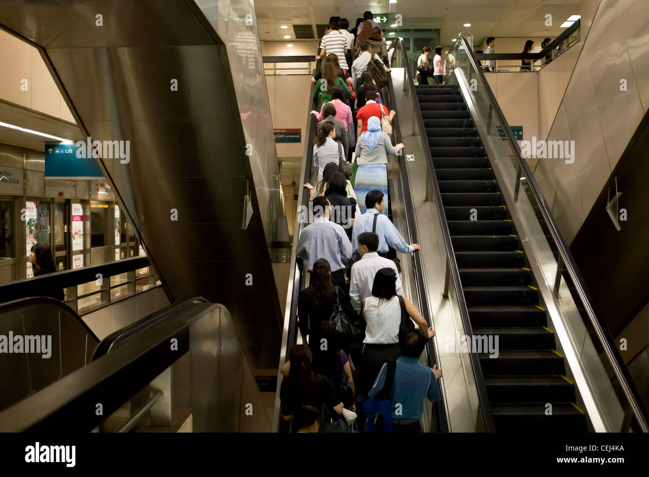 Commuters ride escalators in an Mass Rapid Transit, or MRT, station in ...