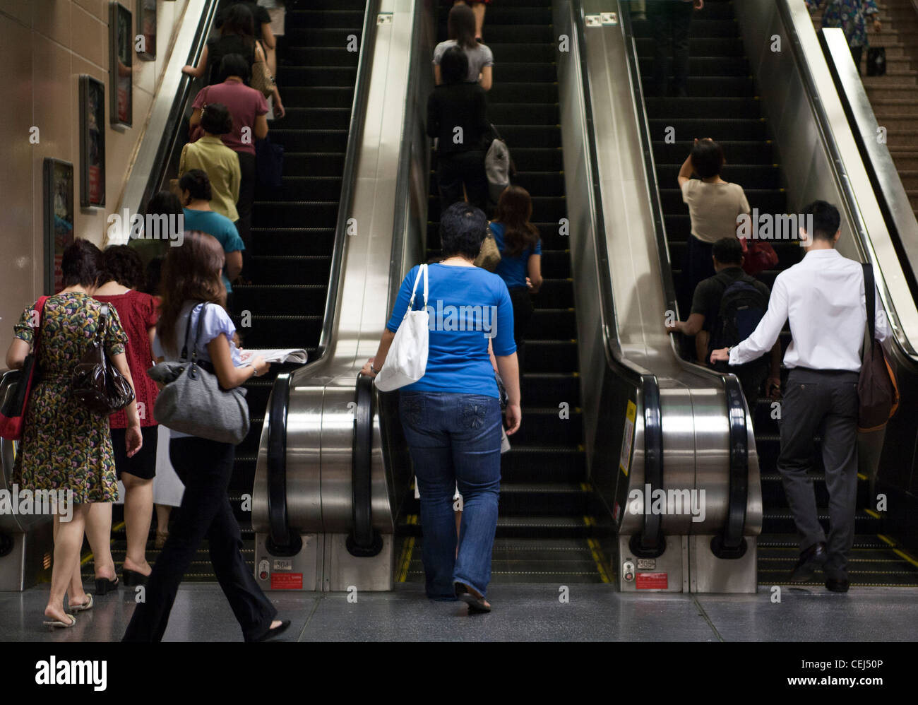 Commuters ride escalators in an Mass Rapid Transit, or MRT, station in ...