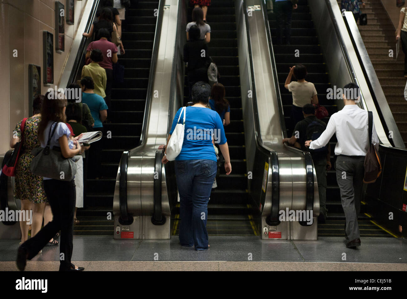 Commuters ride escalators in an Mass Rapid Transit, or MRT, station in ...