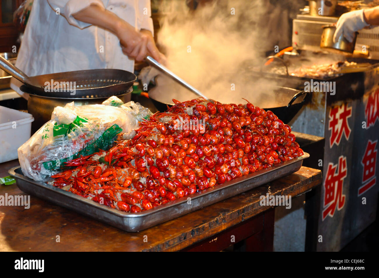 asian cook cooking prawns with a wok on a gas flame Stock Photo - Alamy