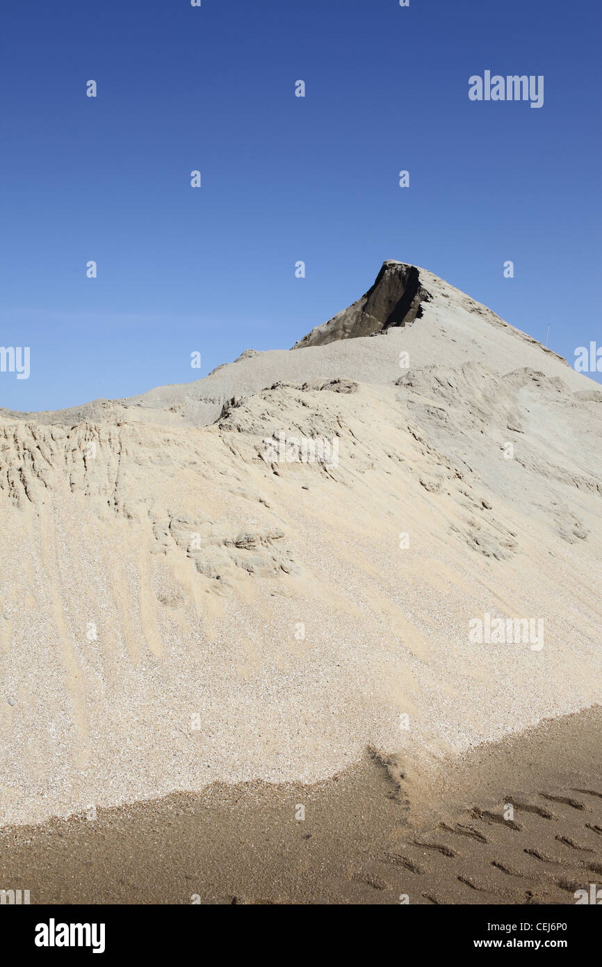 Grey sand mound and clear blue sky Stock Photo - Alamy