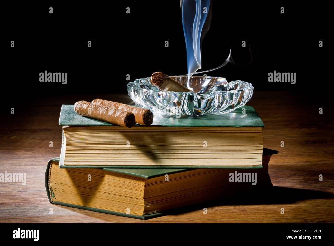Blue smoke from cigar with ashtray and two books volume Stock Photo - Alamy