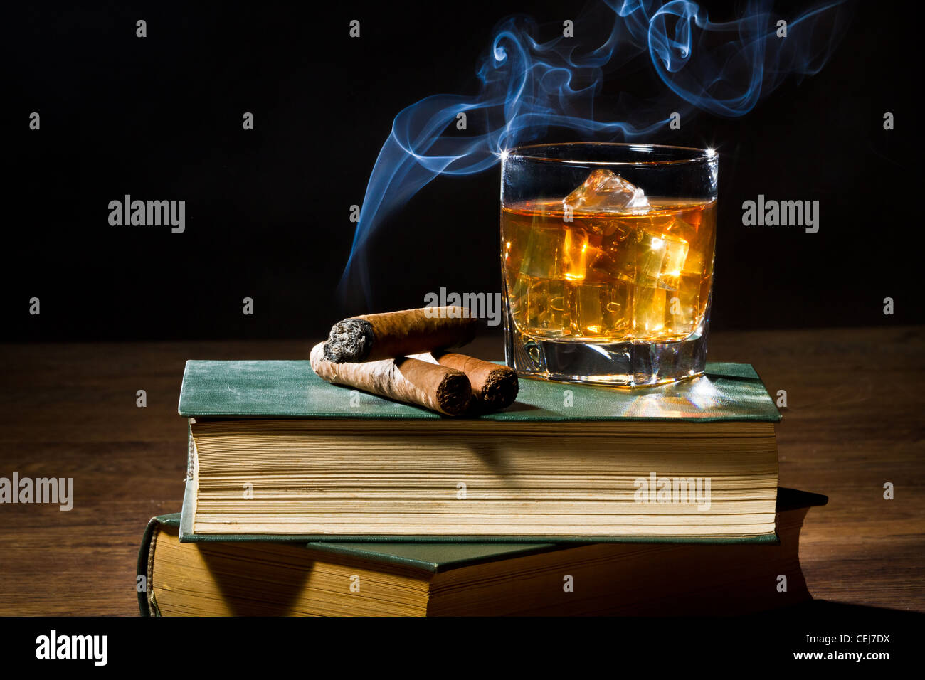 Cigar with blue smoke and whiskey on ice and two books volume Stock ...