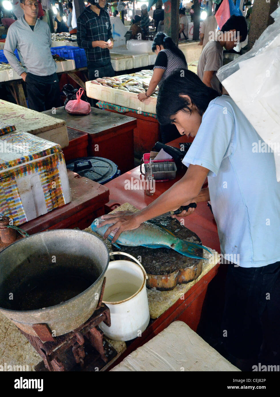 Fresh fish being filleted by woman at Jimbaran local fish market, near ...
