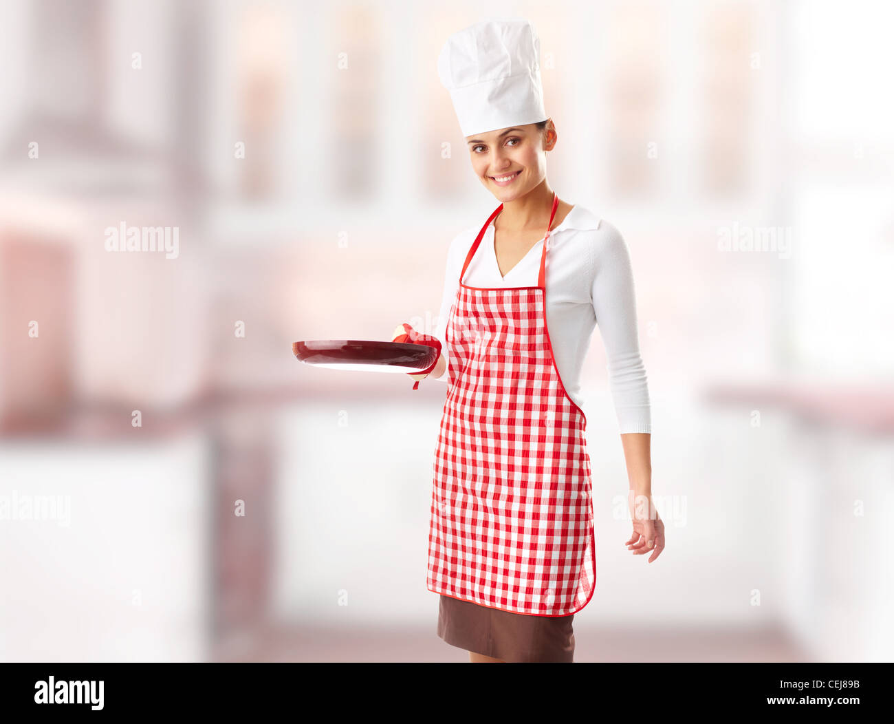 Portrait of happy female with frying pan looking at camera on creative ...