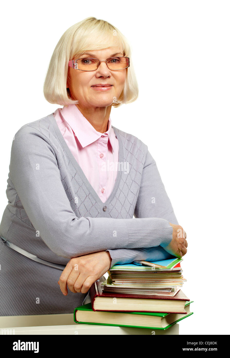 Pretty elderly lady leaning over a pile of books isolated on white ...
