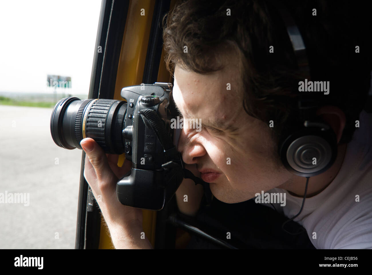 Young man with dslr camera shooting from car Stock Photo - Alamy