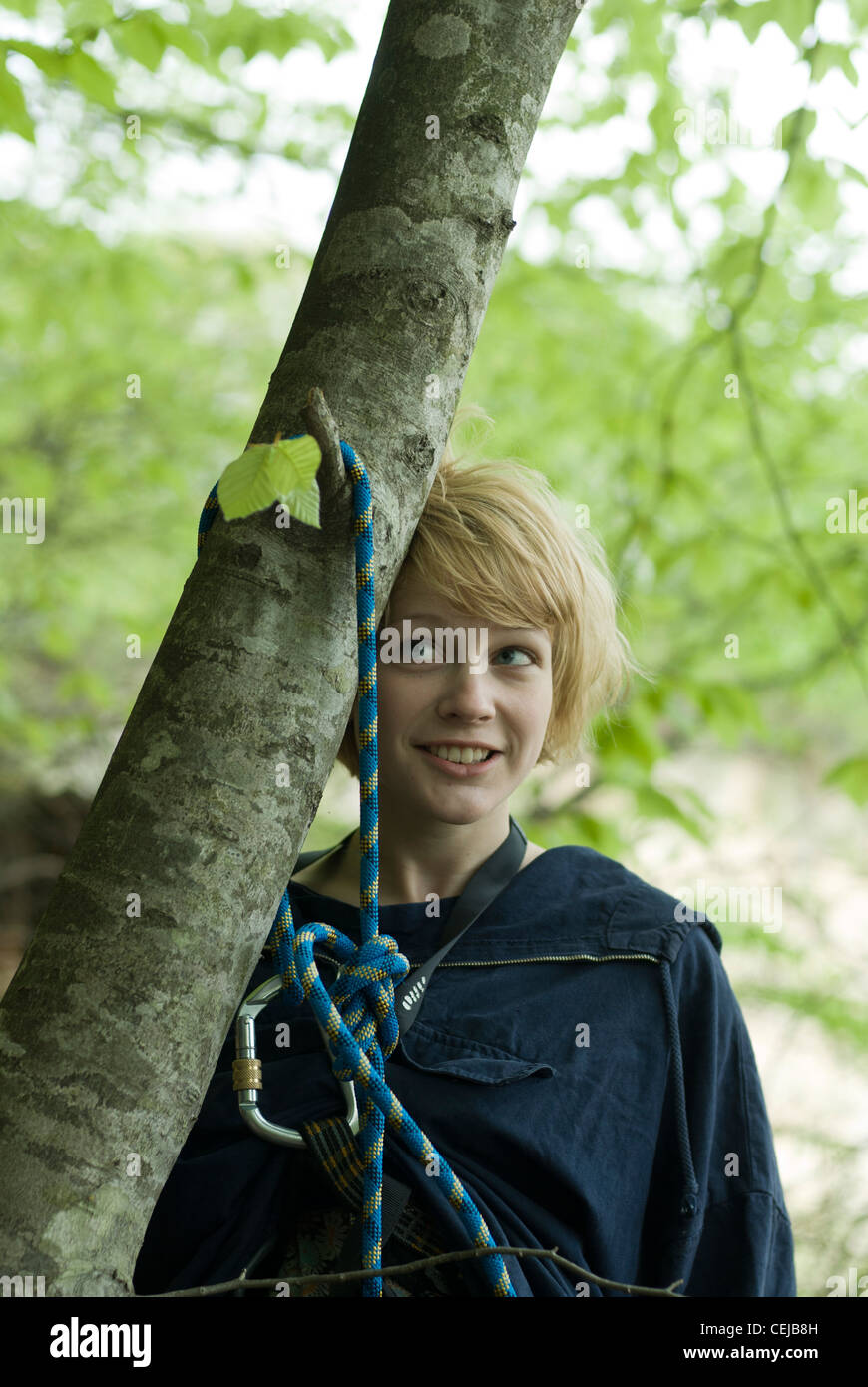 Blond woman tied with safety ropes to a tree Stock Photo - Alamy