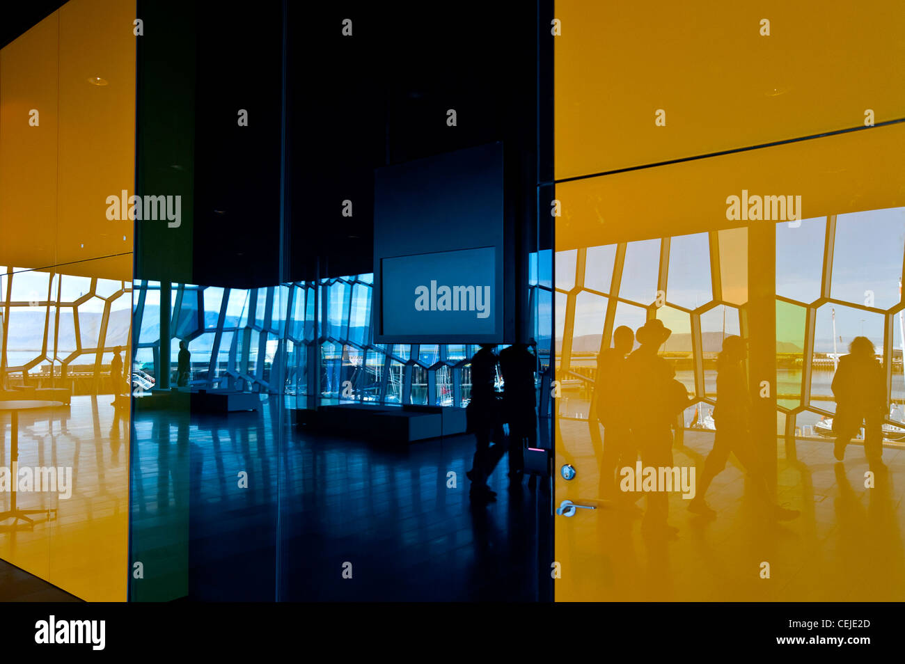 Reflection of group of people in colorful wall touring Harpa "The Harp ...