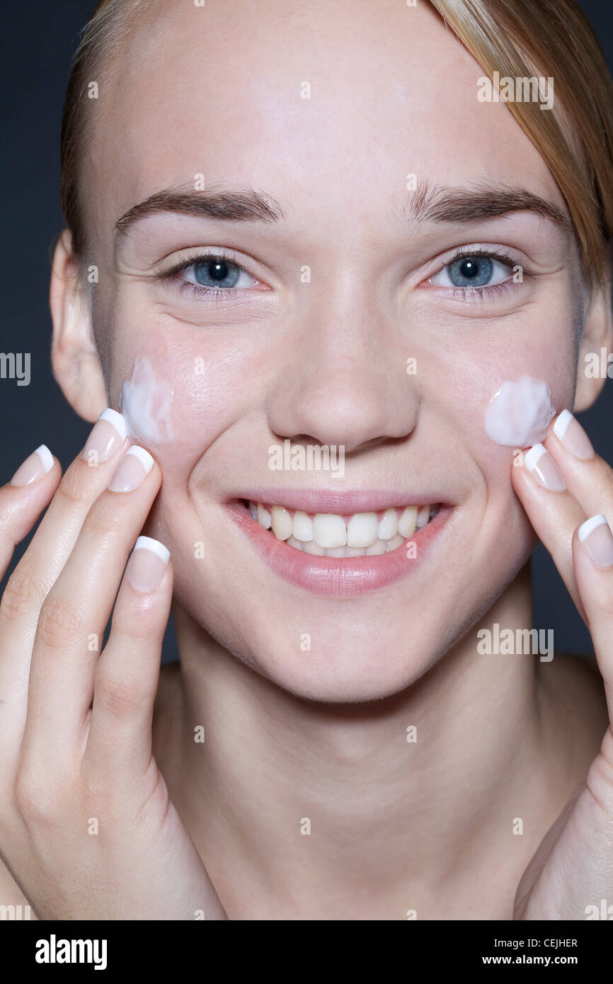 Step by Step Beauty and Make Up Female applying face cream to her cheek ...