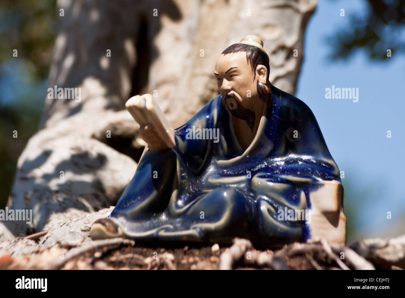 A little painted porcelain statue of a traditional Chinese man how read ...