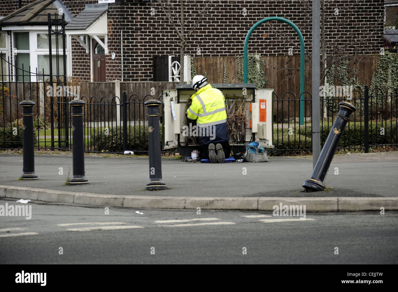 Openreach engineer working on pavement sited telephone junction box ...