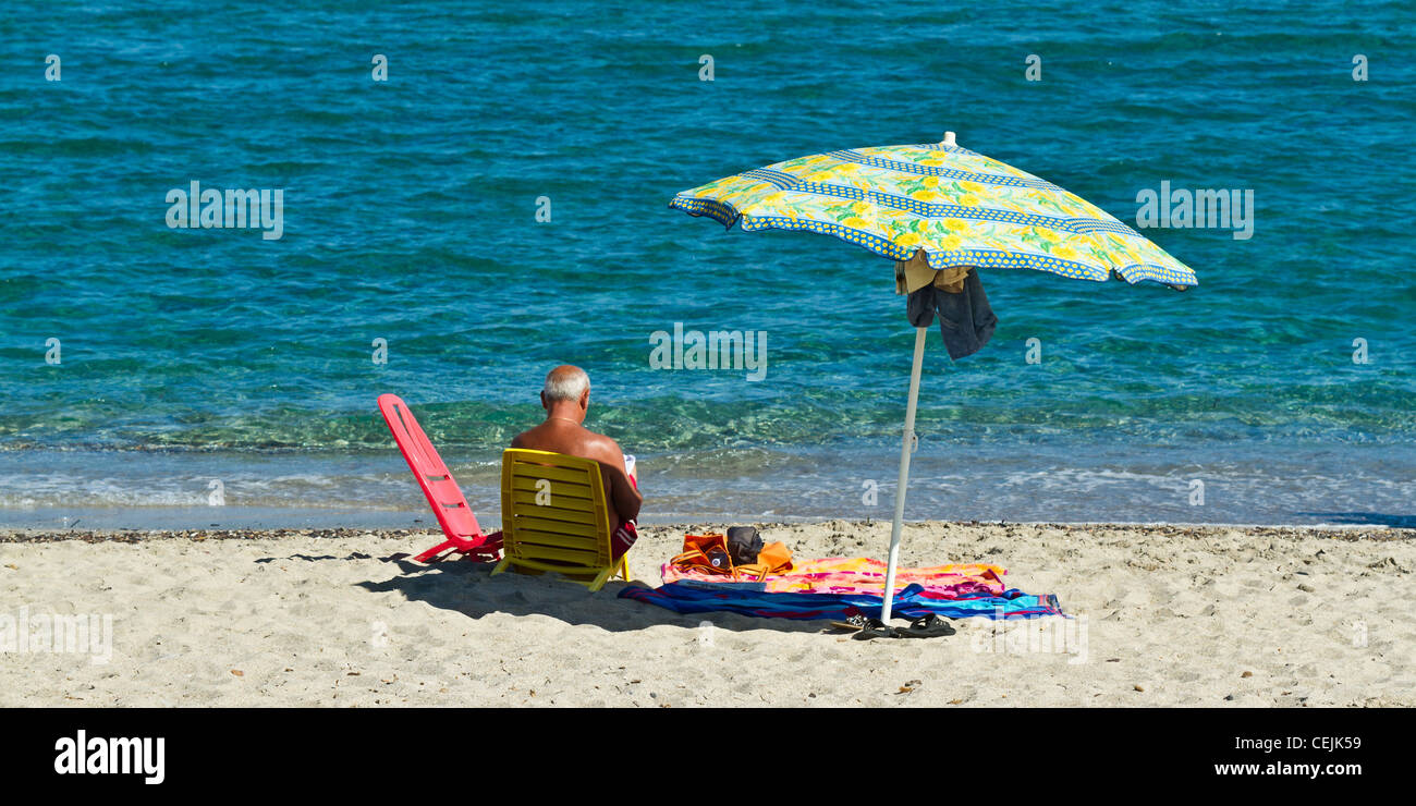lone man relaxing on the beach in summer Stock Photo - Alamy