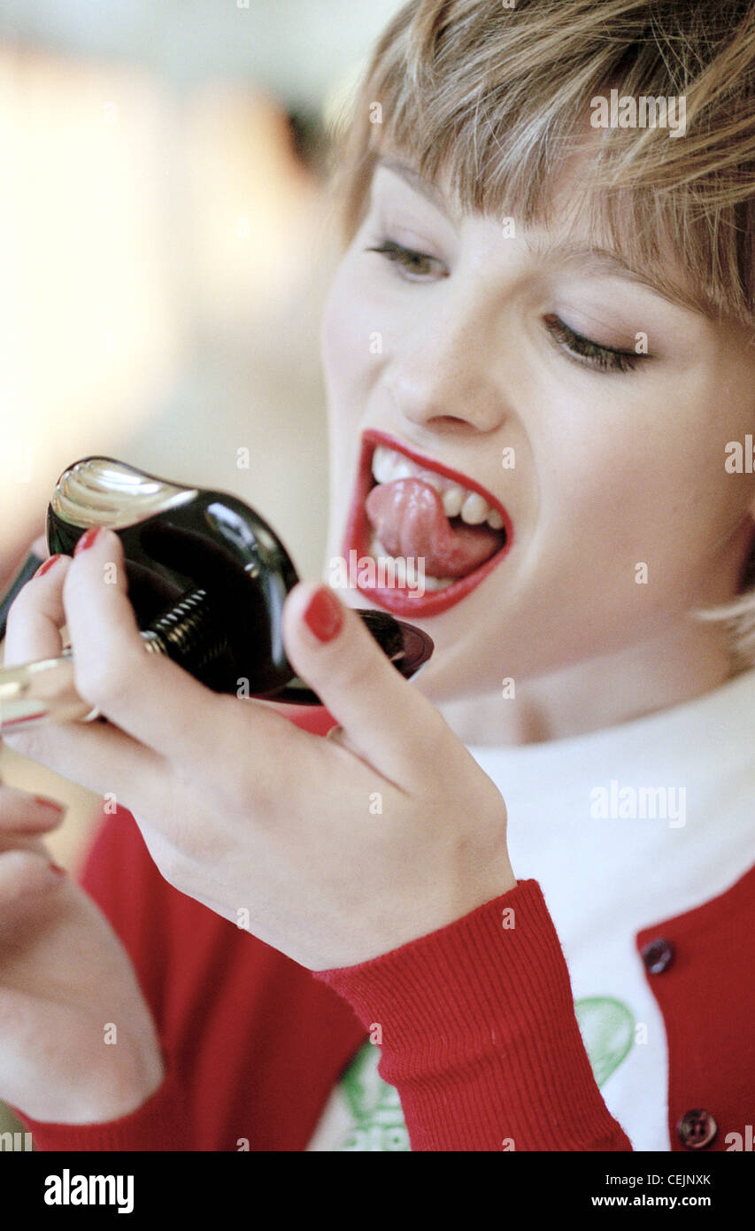 Female with short fair hair, wearing red cardigan, checking teeth in ...