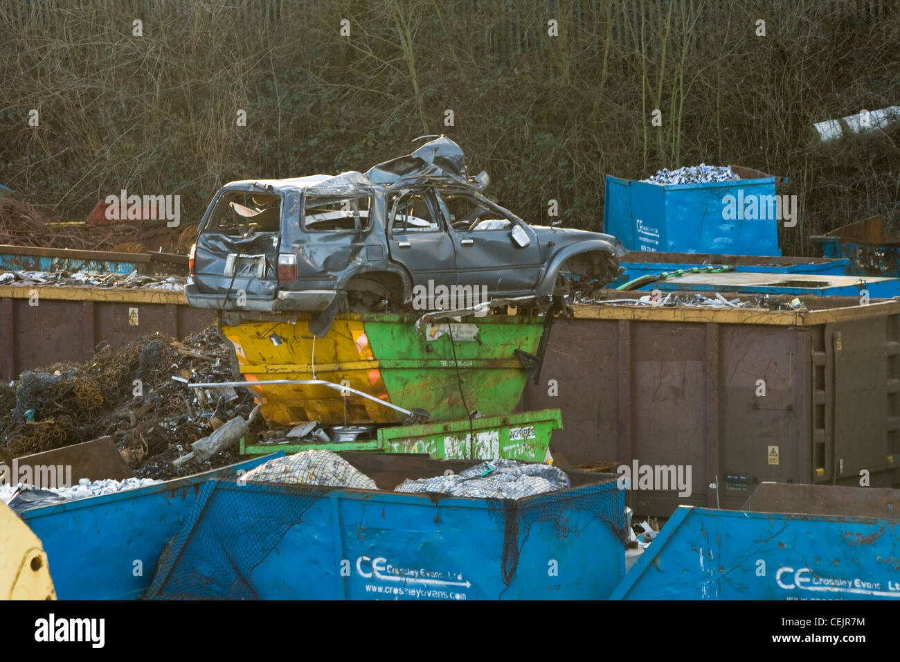A car on the top of skips in a scrapyard Stock Photo - Alamy