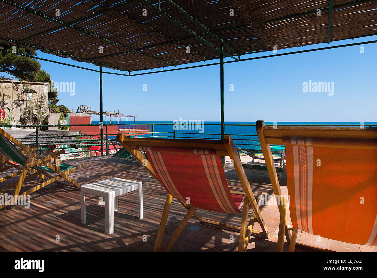 empty deck chairs on terrace, under canopy at beach club capri, italy ...