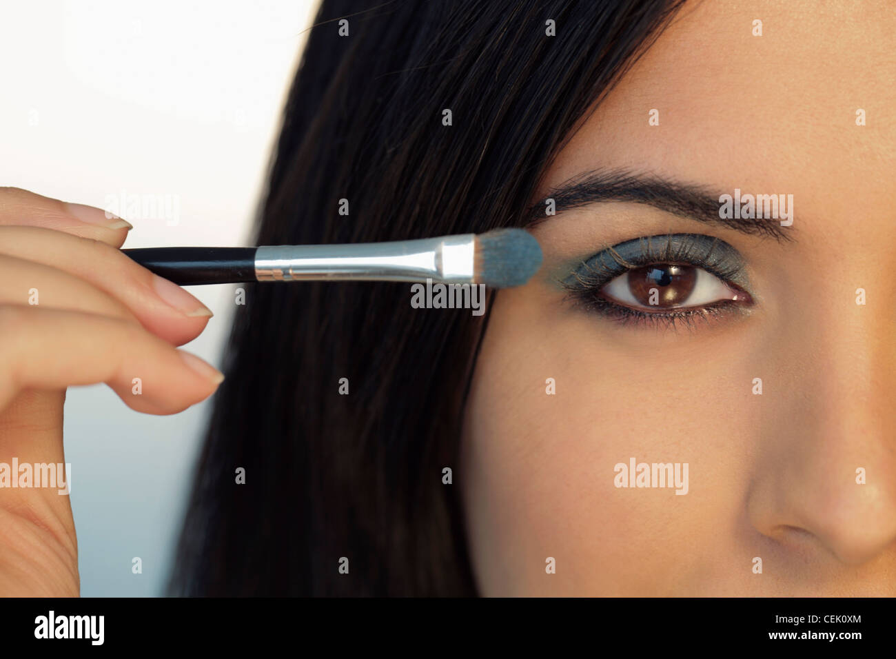 Cropped shot of young woman putting on eye make up Stock Photo - Alamy