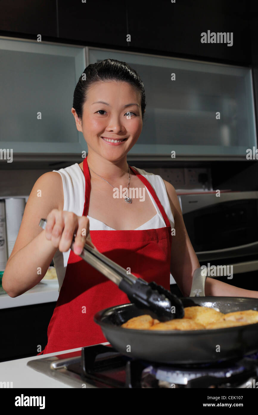 Chinese woman cooking in kitchen Stock Photo - Alamy