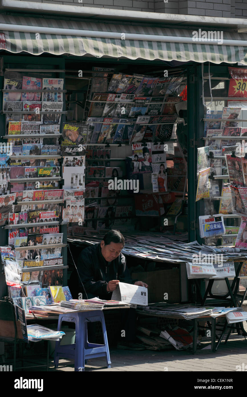 Woman selling magazines in a street stall, Shanghai, China Stock Photo ...