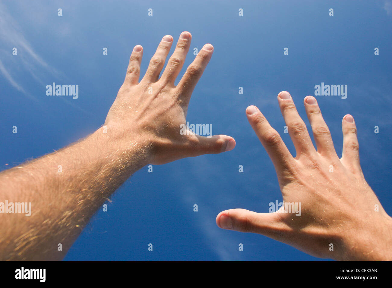 Two male hands stretching to reach the sky Stock Photo - Alamy