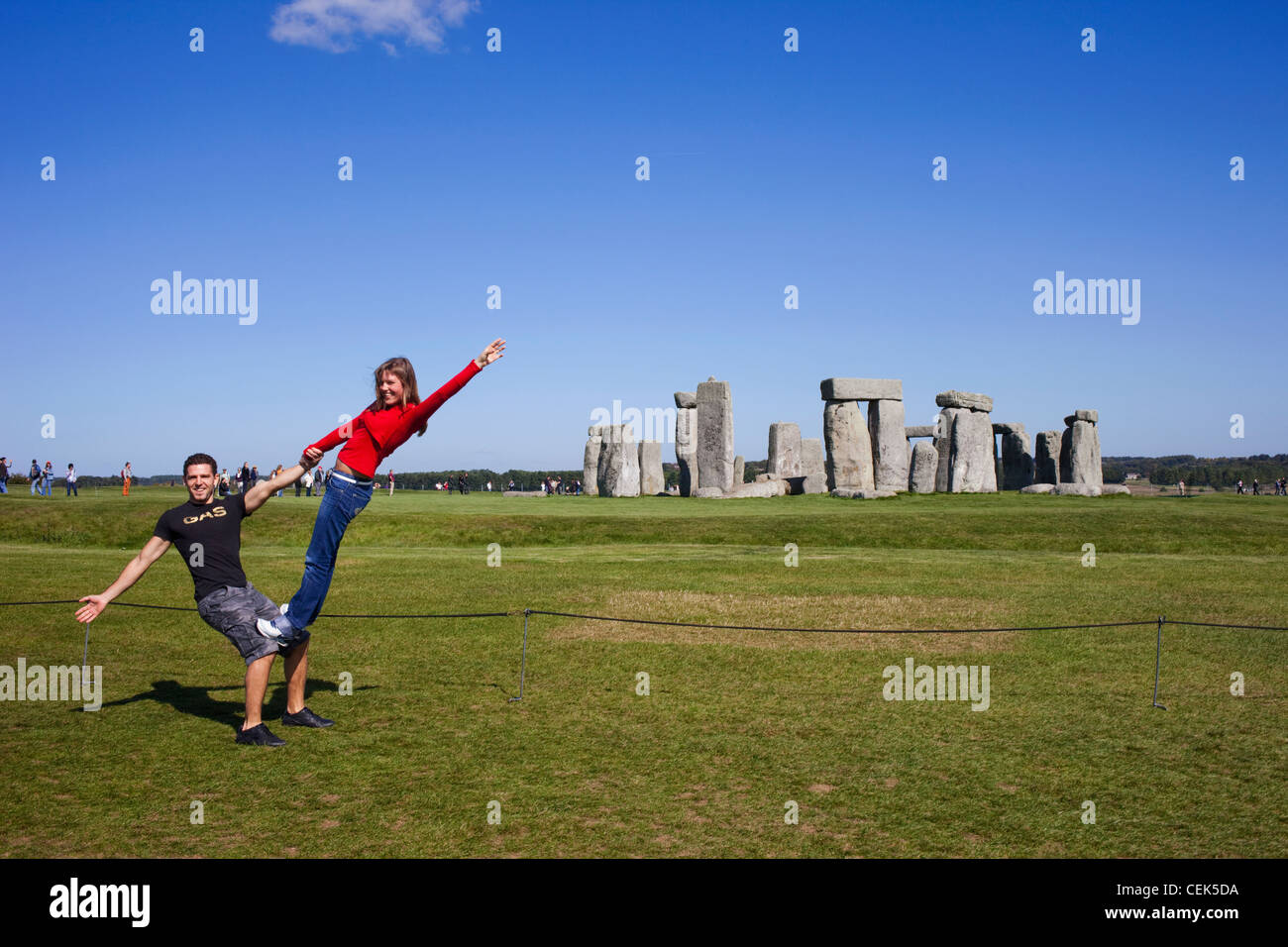 England, Wiltshire, Stonehenge, Tourists posing for photographs at ...