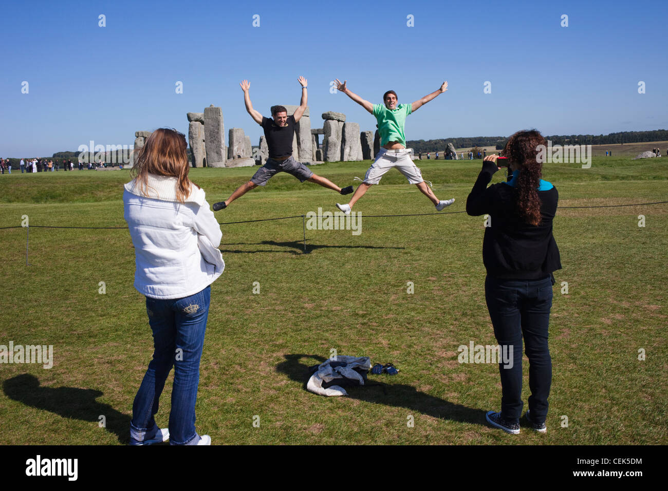 England, Wiltshire, Stonehenge, Tourists posing for photographs at ...