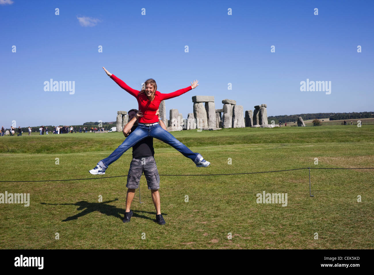 England, Wiltshire, Stonehenge, Tourists posing for photographs at ...