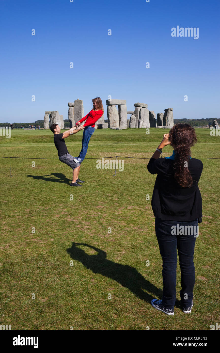 England, Wiltshire, Stonehenge, Tourists posing for photographs at ...