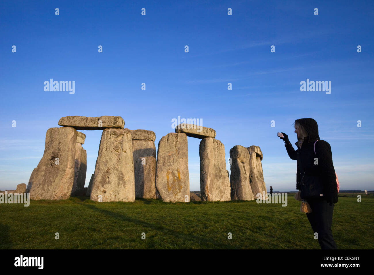 England, Wiltshire, Stonehenge, Tourists posing for photographs at ...