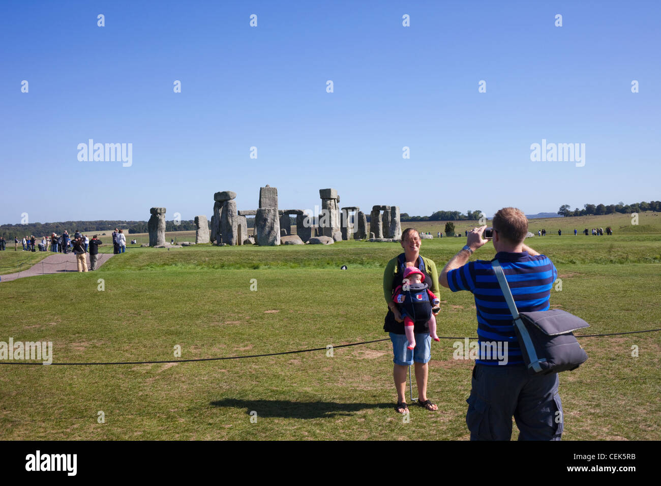 England, Wiltshire, Stonehenge, Tourists posing for photographs at ...