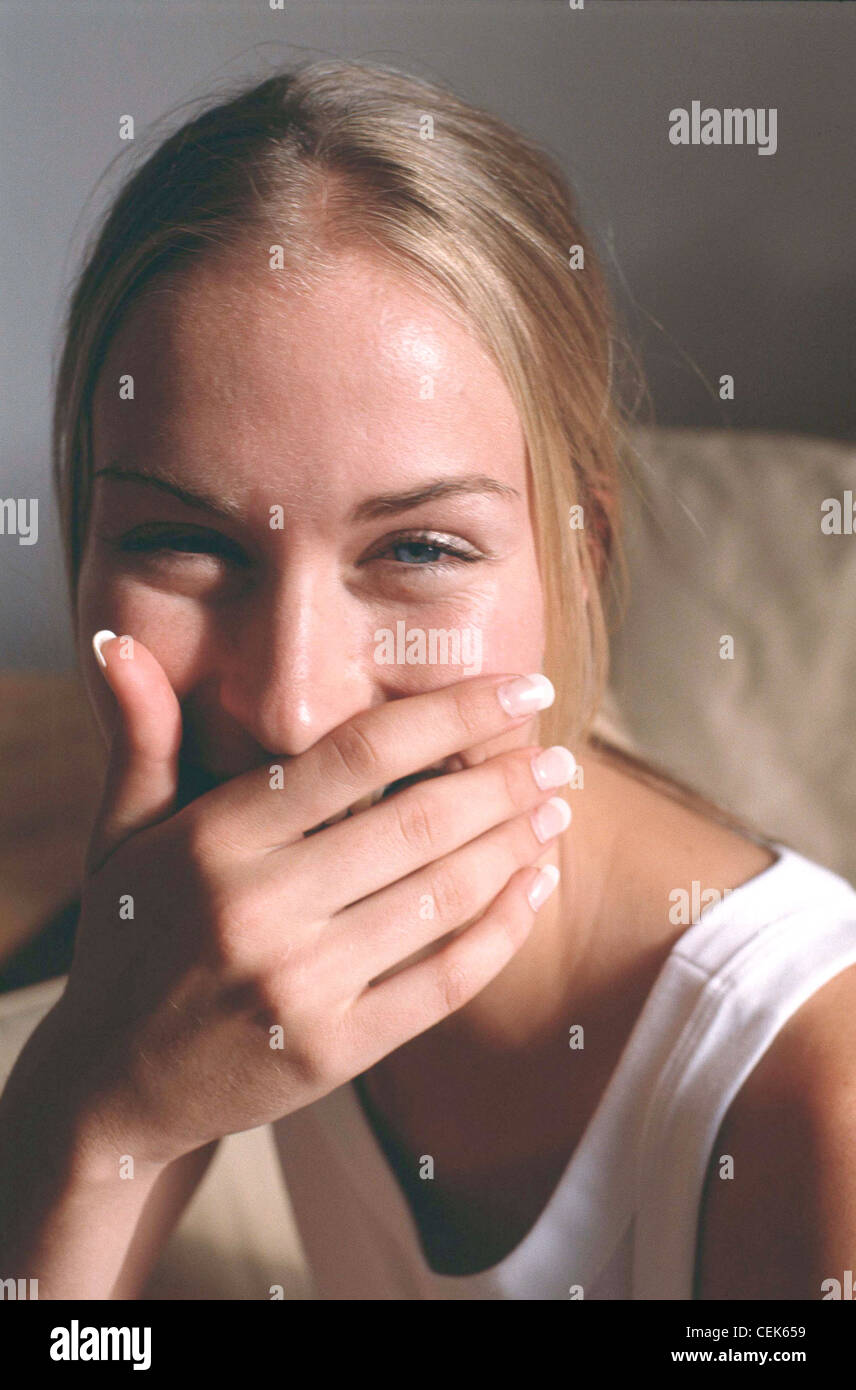 Female long fair hair in loose ponytail wearing white vest top and ...