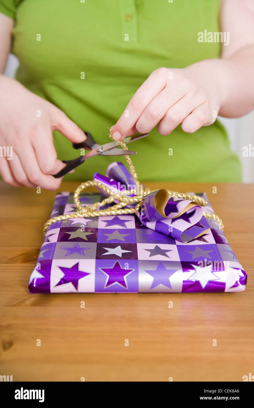 Blonde woman wrapping a gift Stock Photo - Alamy