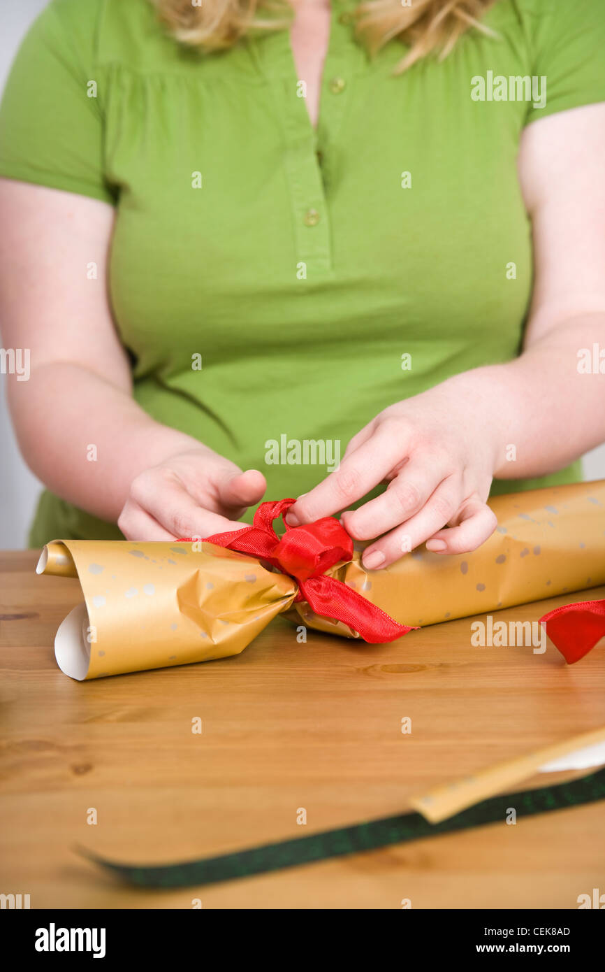 Blonde woman wrapping a gift Stock Photo - Alamy