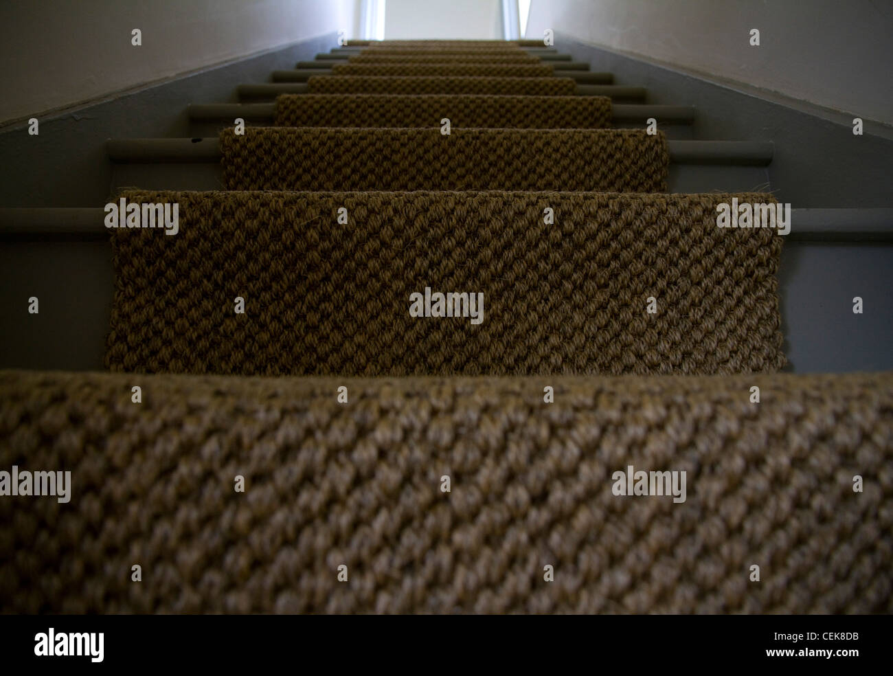 A rustic staircase with a sisal runner carpet in an old-fashioned ...