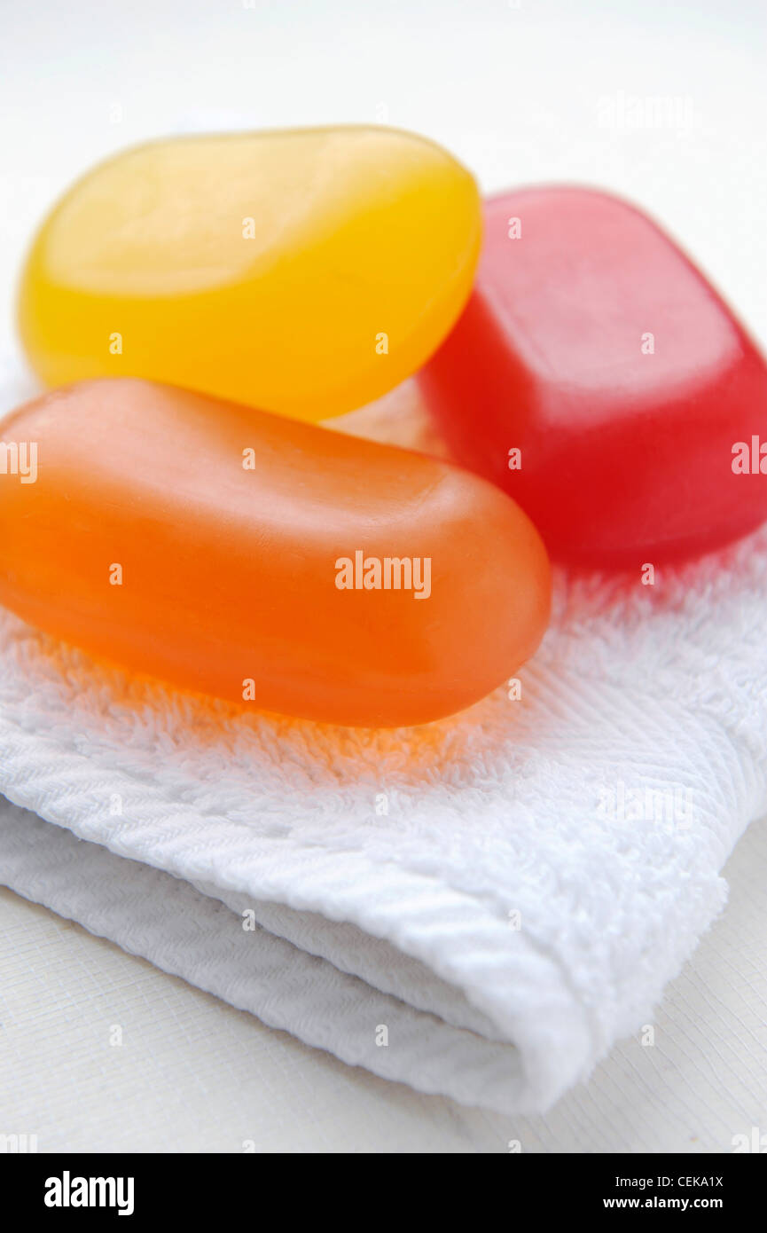 Red, orange and yellow bars of soap, on a white folded flannel Stock ...